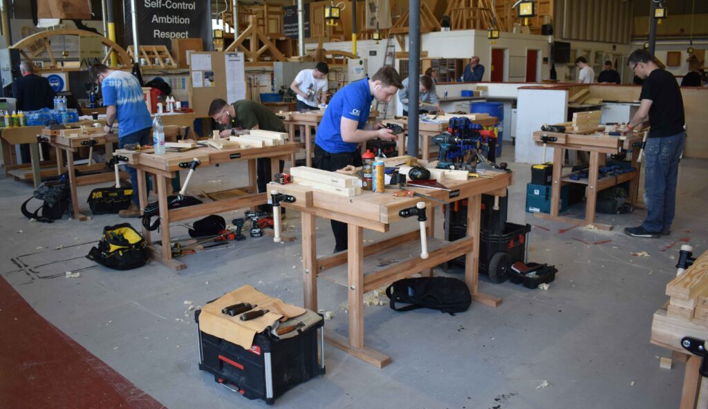 Three carpentry students from West Suffolk College carve their names ...